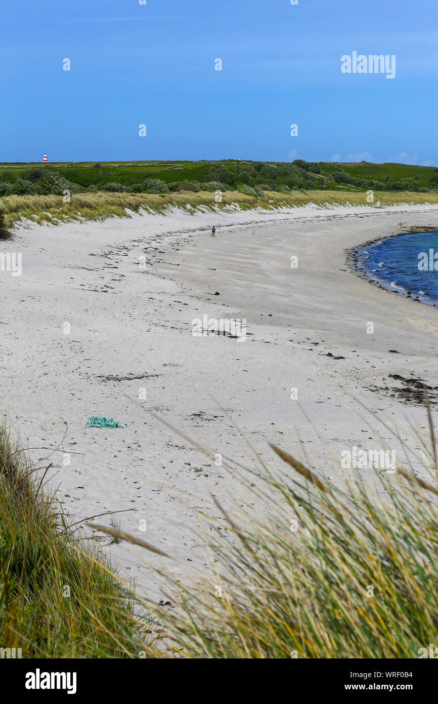 A solitary person walking on Higher Town Bay, St. Martin’s Island ...