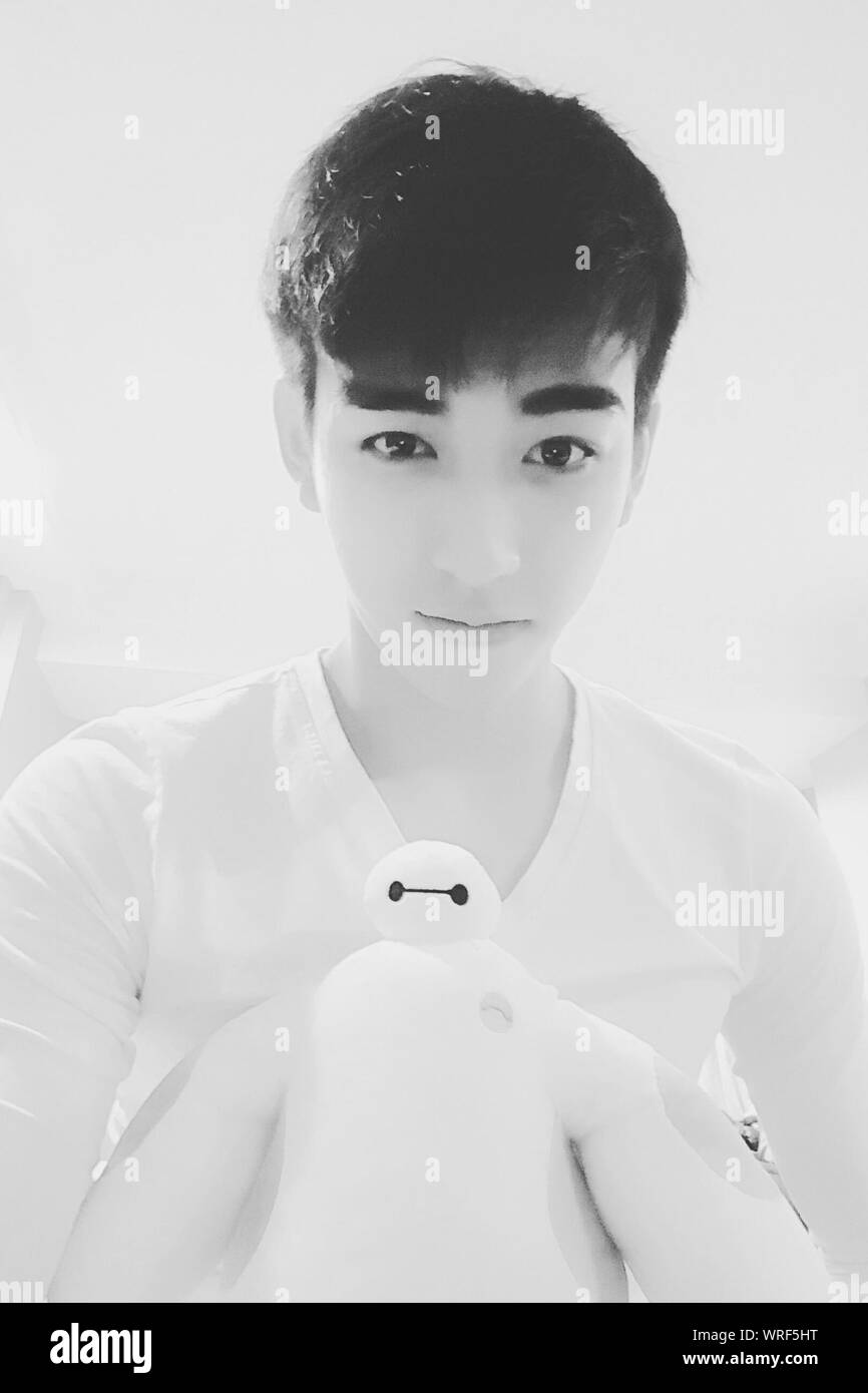 Portrait Of Young Man Holding Stuffed Toy Against White Background ...