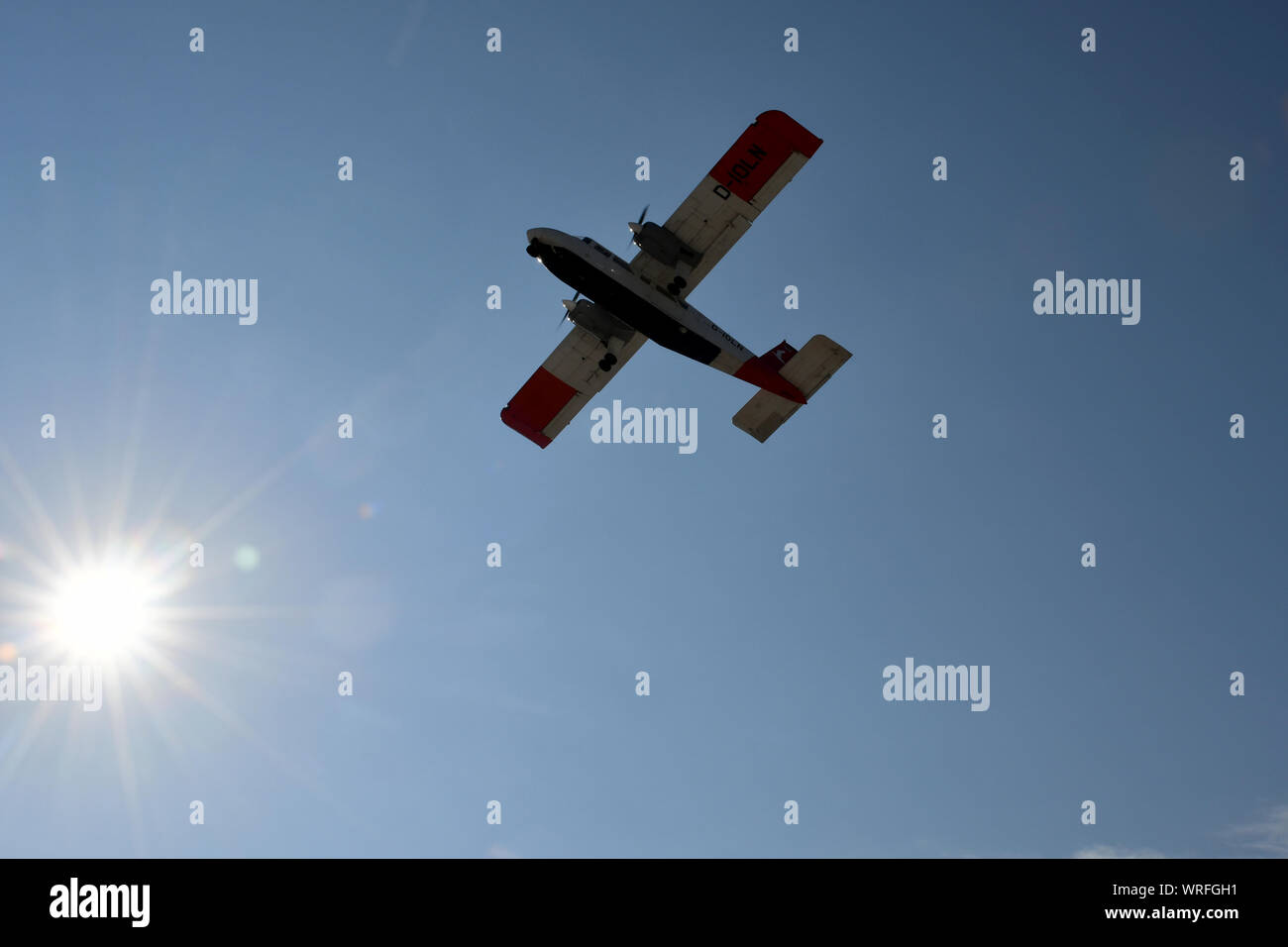 Airplane in the sky with the sun shining Stock Photo - Alamy