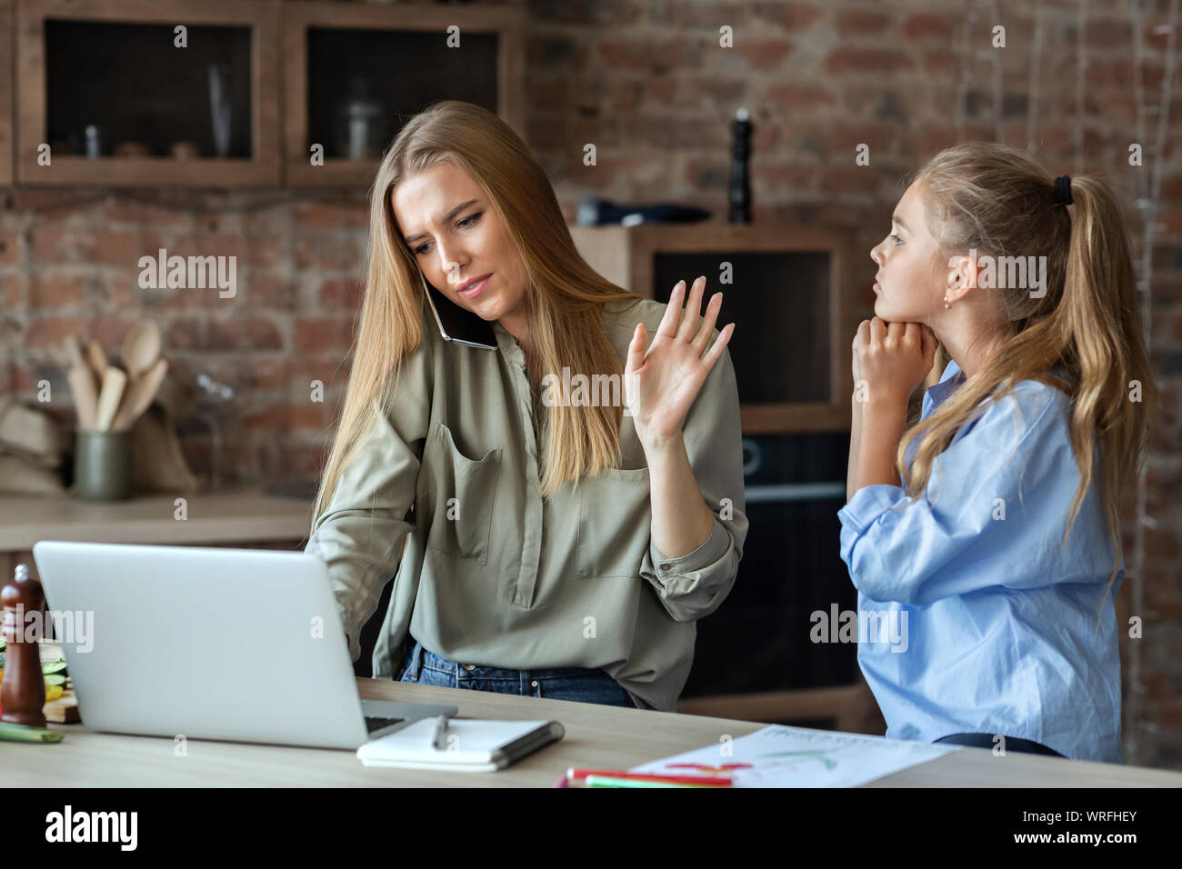 Girl begging her busy mom for attention Stock Photo - Alamy