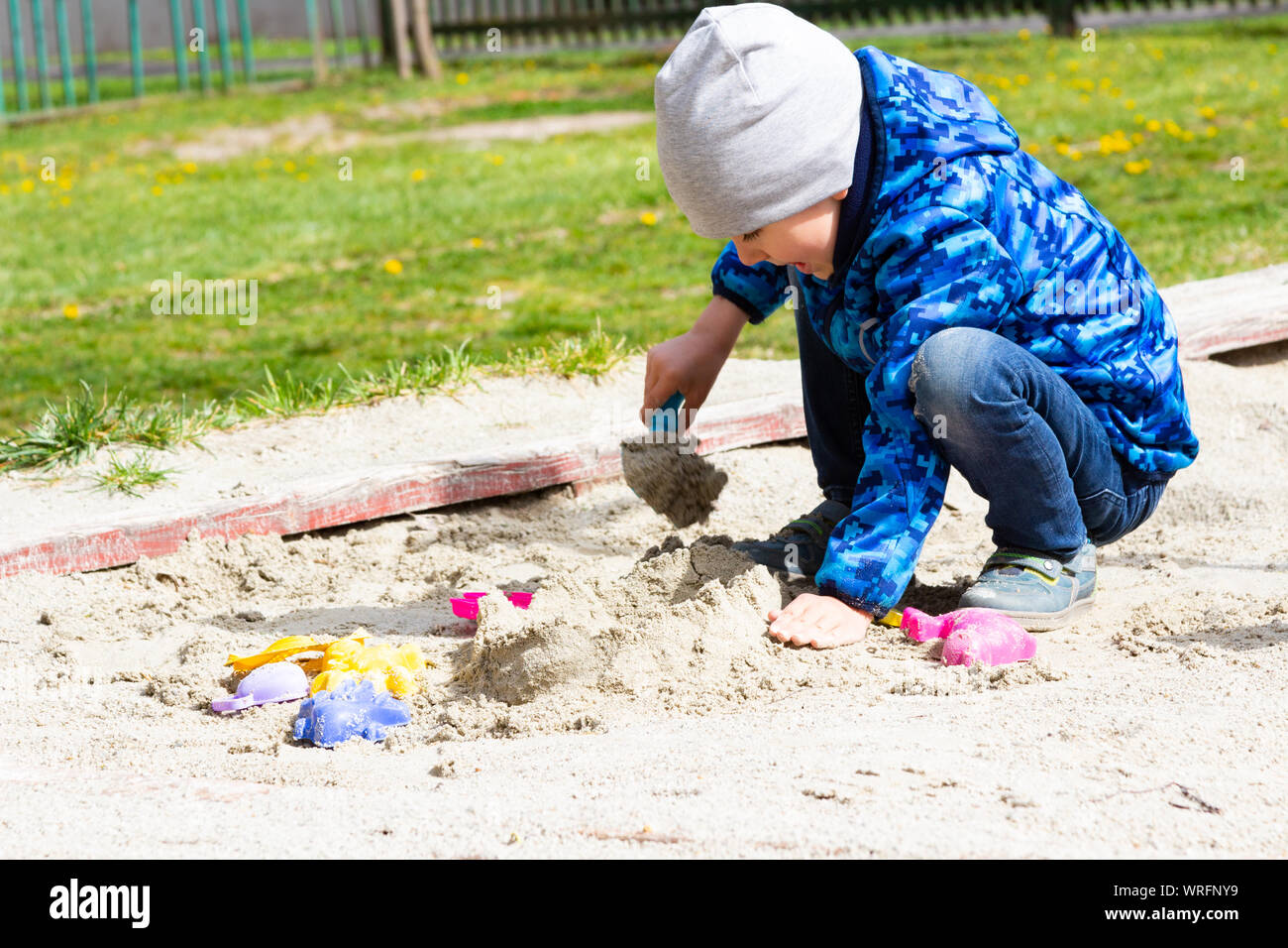Boy child playing with toy shovel in sandbox at playground Stock Photo ...