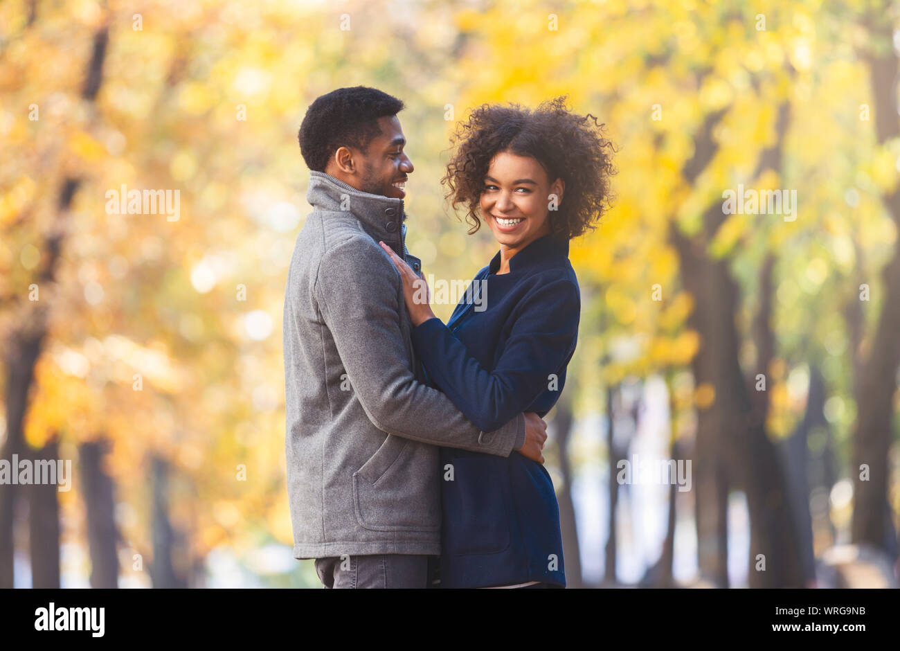 African american young couple cuddling in golden park Stock Photo - Alamy