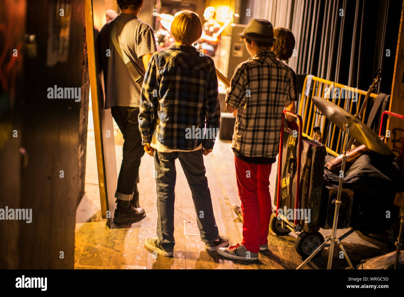 Group of teenage boys watching a band playing on stage Stock Photo - Alamy