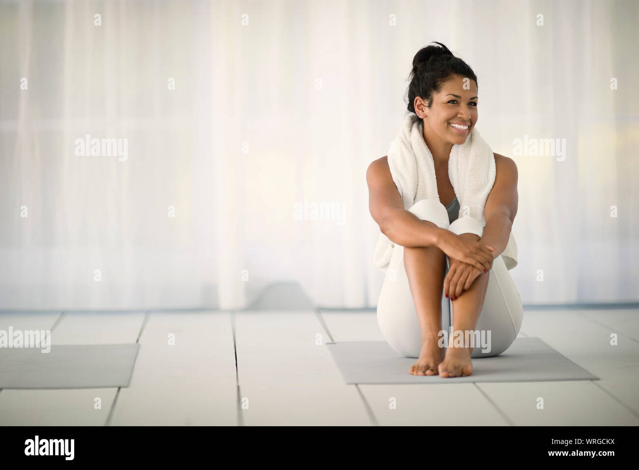 Smiling young woman relaxing after working out Stock Photo - Alamy