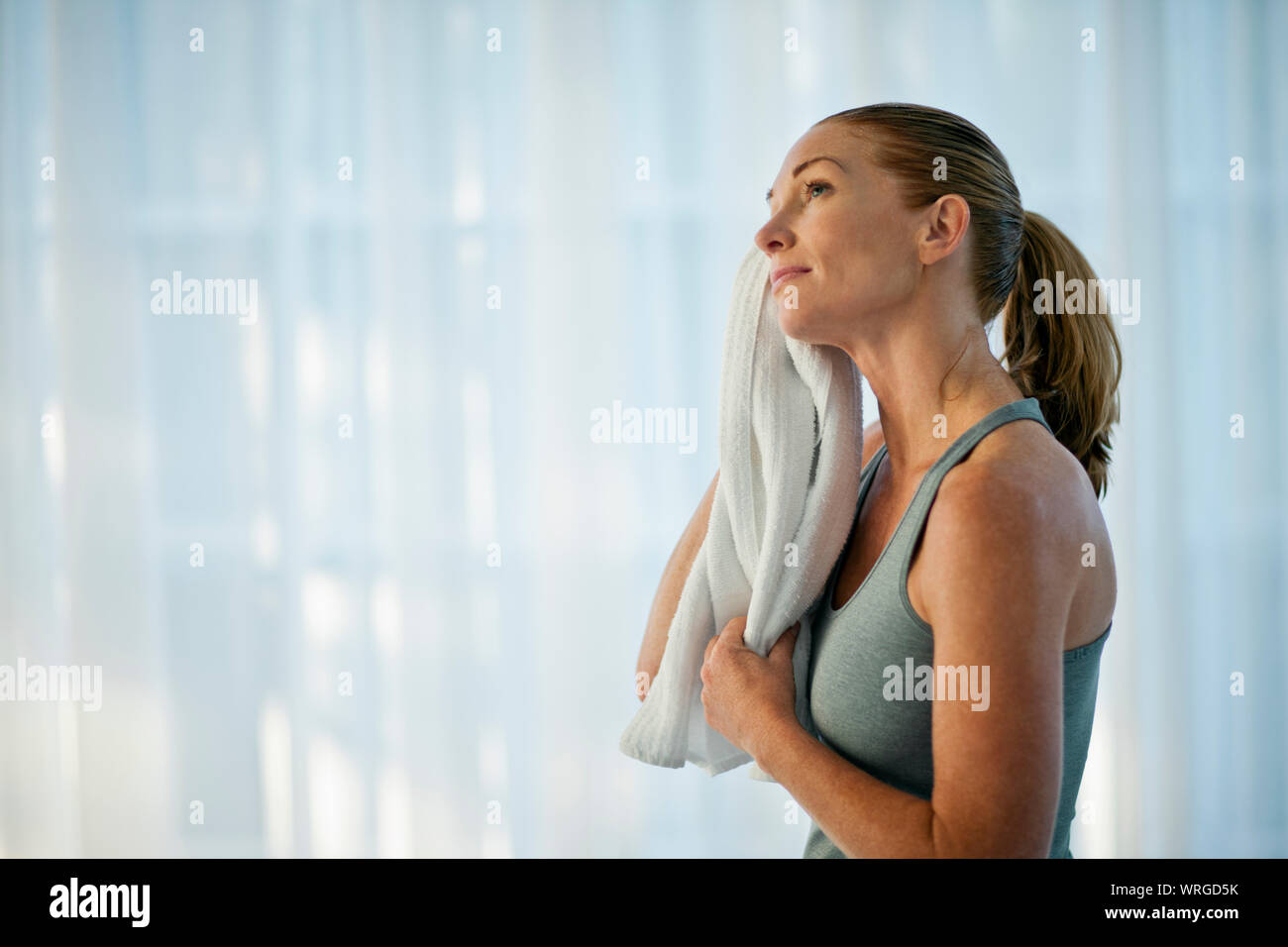 Happy mid adult woman drying off after a yoga class Stock Photo - Alamy