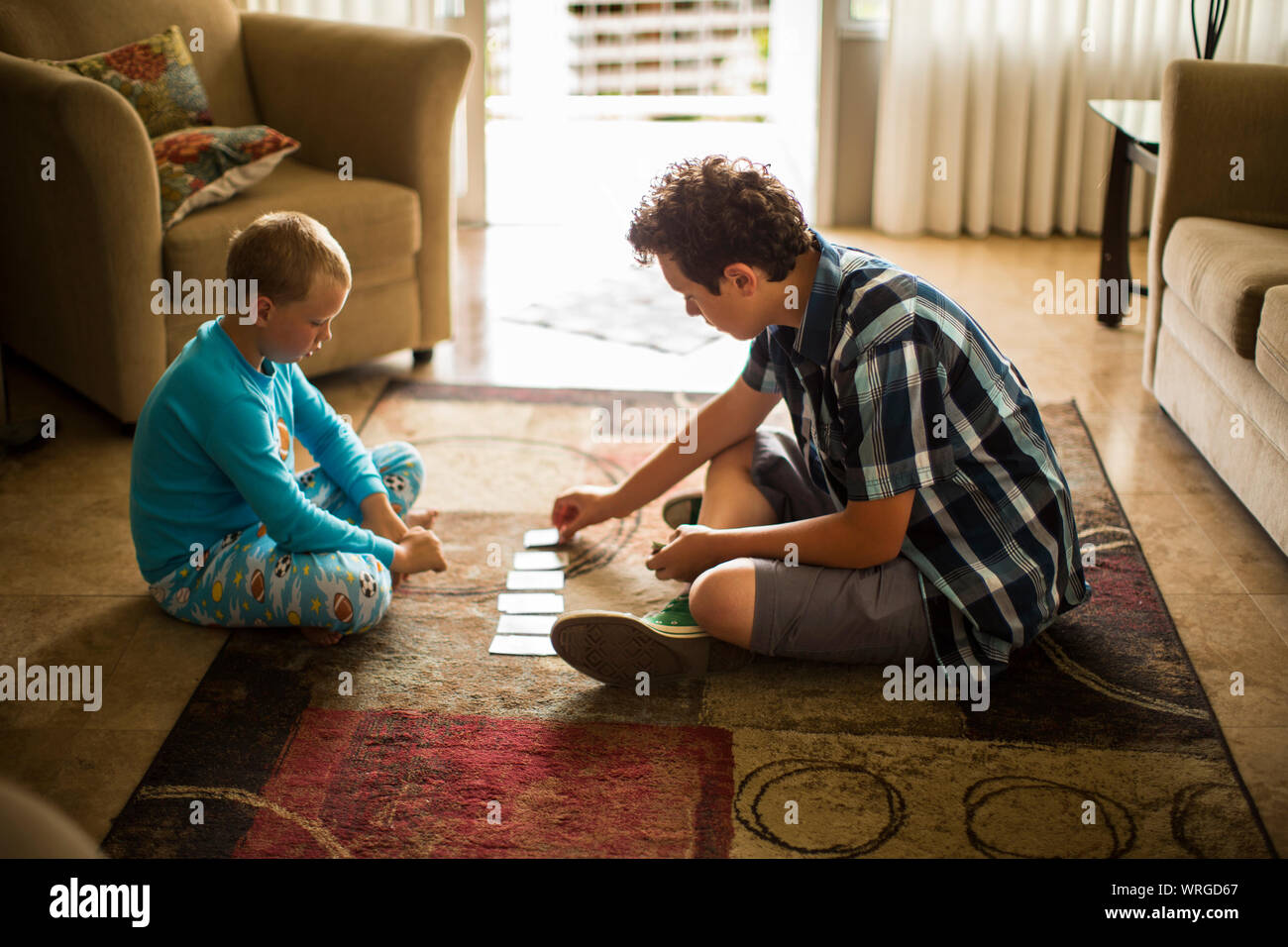 Two boys playing a card game on a living room floor Stock Photo - Alamy