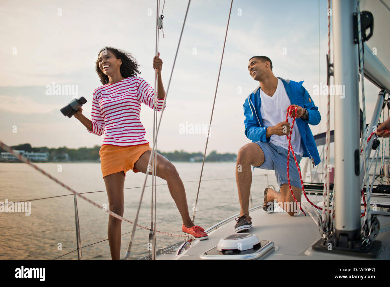 Happy young couple having fun with binoculars while sailing Stock Photo ...