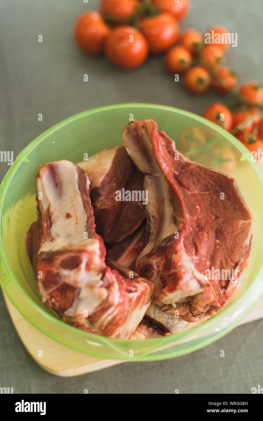 meat on the bone in a plastic vessel. fresh meat for cooking Stock ...