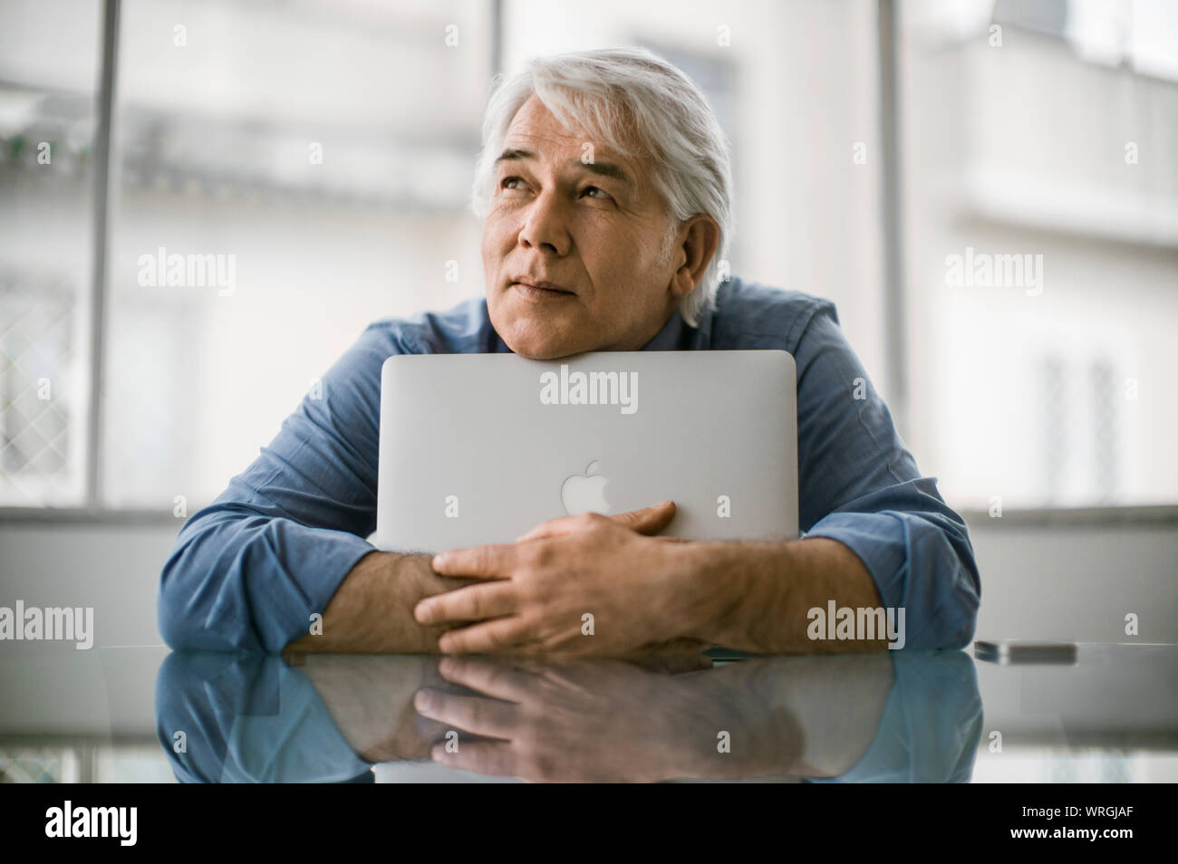 Content mature businessman hugging his laptop computer Stock Photo - Alamy