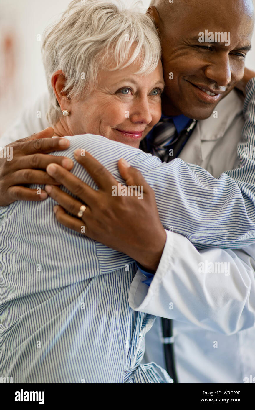 Cheerful mature woman thanks her doctor by giving him a hug Stock Photo ...