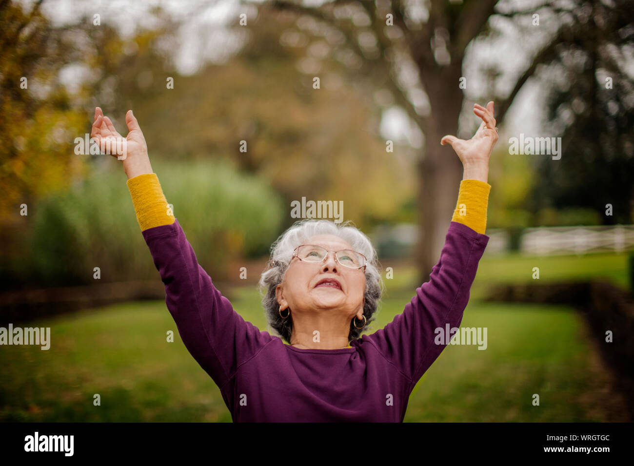 Happy senior woman throwing her arms up in the air with joy Stock Photo ...