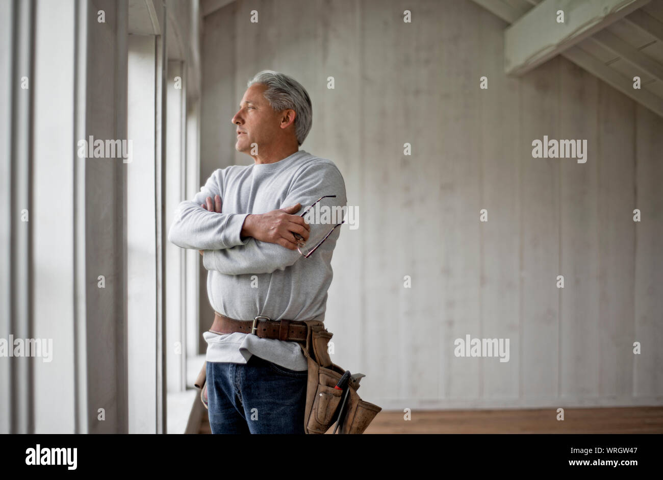 Builder thinking while staring out window Stock Photo - Alamy
