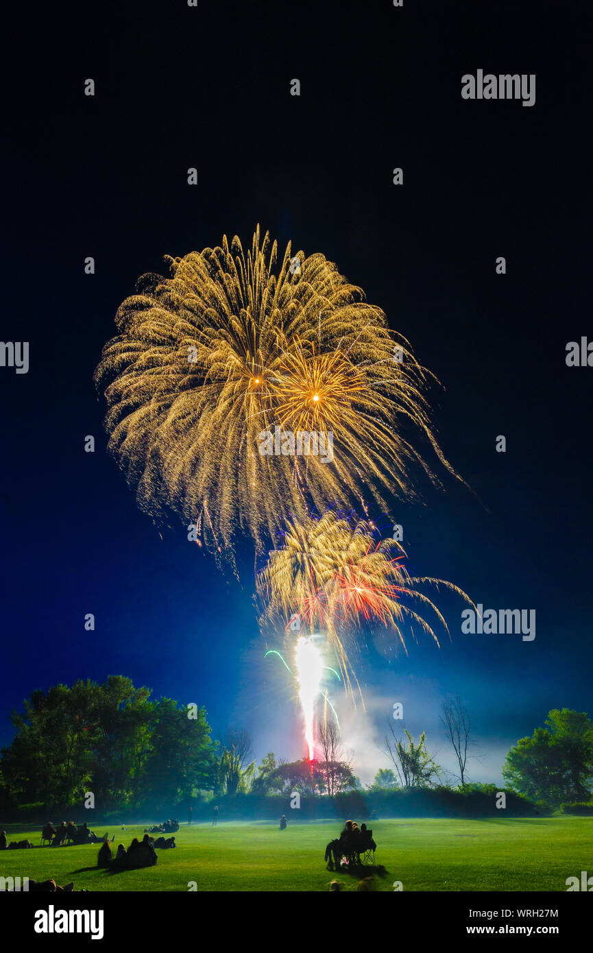 4th of July fireworks over a mountain meadow at dusk, Stowe, Vermont ...