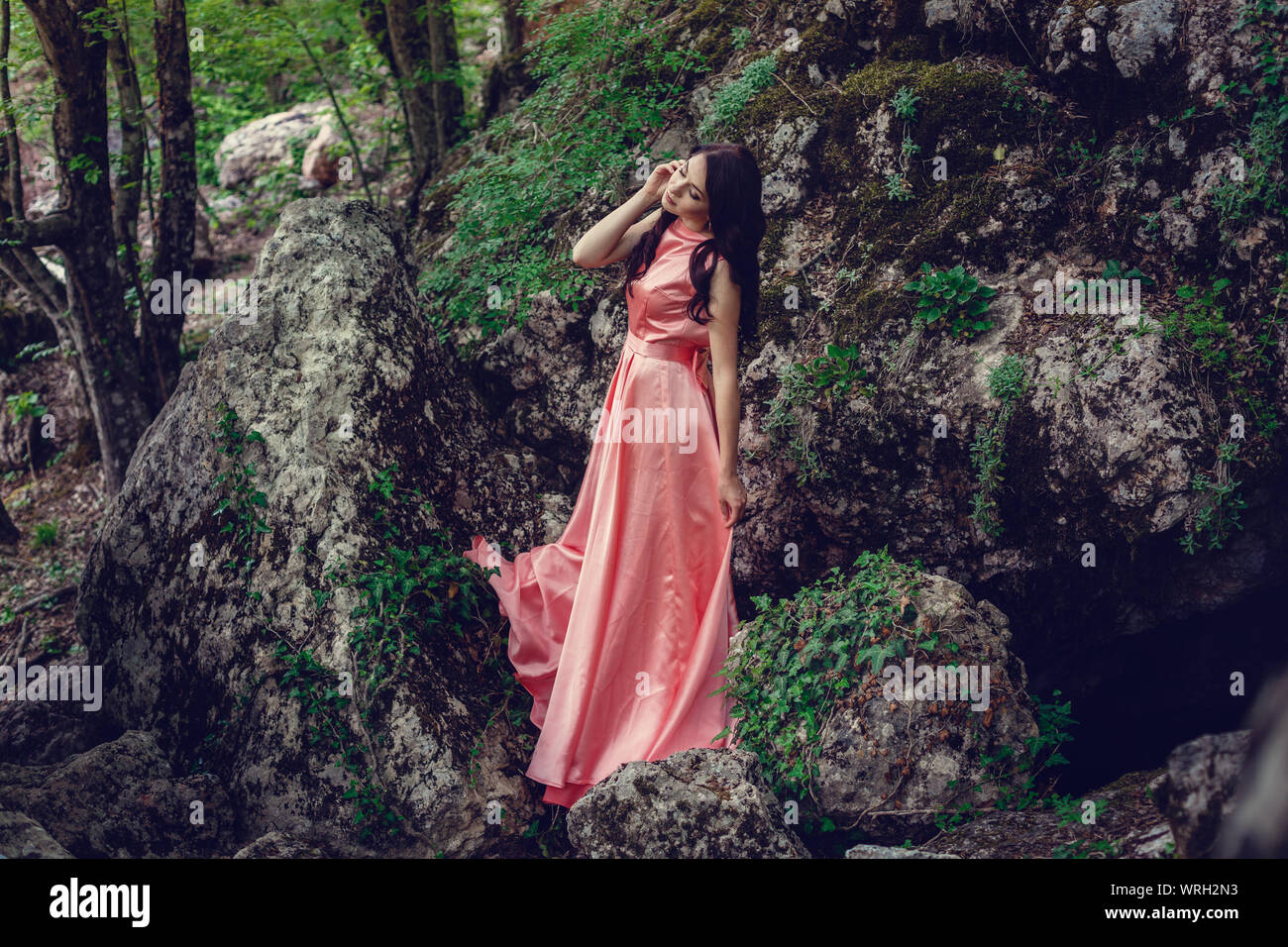 River witch, sitting on a rock in river. Pink long dress, a fabulous ...