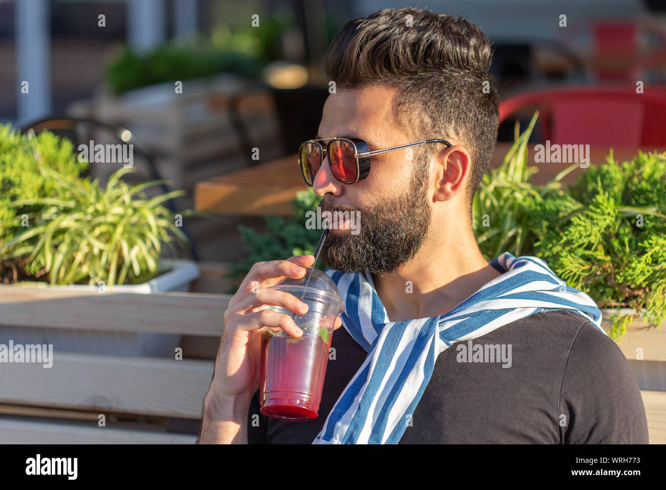 Portrait of a positive cheerful young man with a glass of juice with a ...