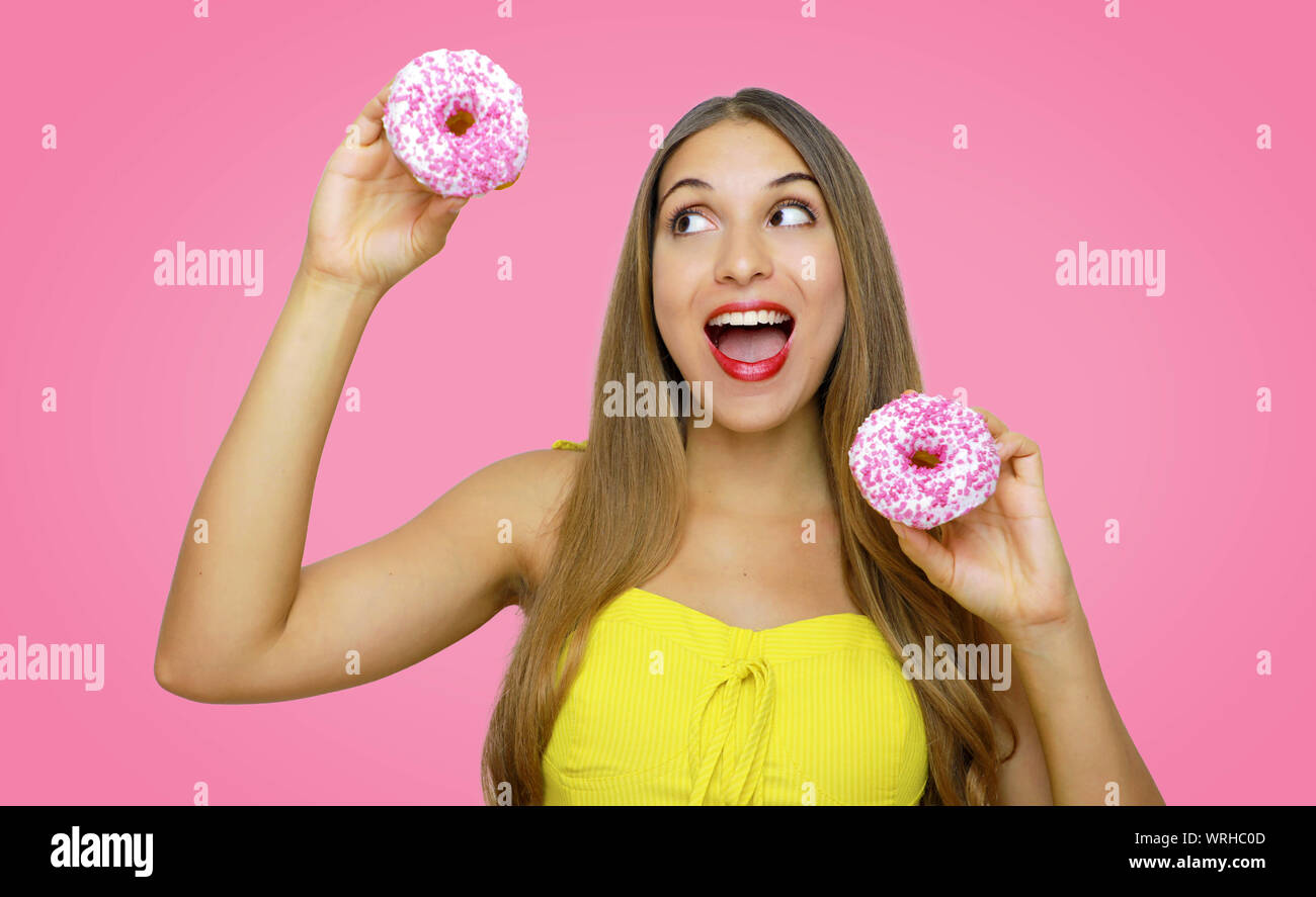 Pretty beautiful young girl playing with donuts looking to the side on ...