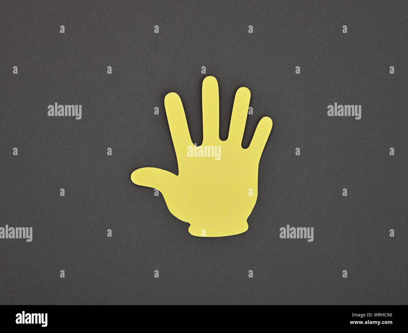 Paper made yellow STOP or HI hand gesture sticker over grey background ...