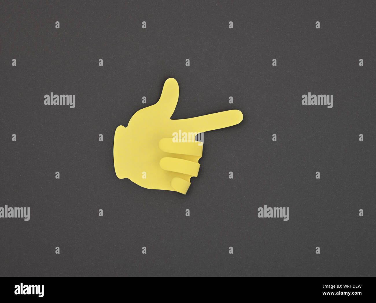 Paper made yellow hand gesture sticker pointing with index finger over ...