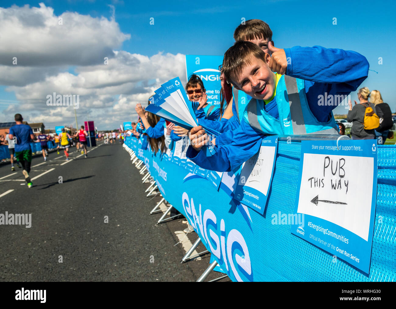 Race supporters out to cheer competitors with banners and signs at the ...