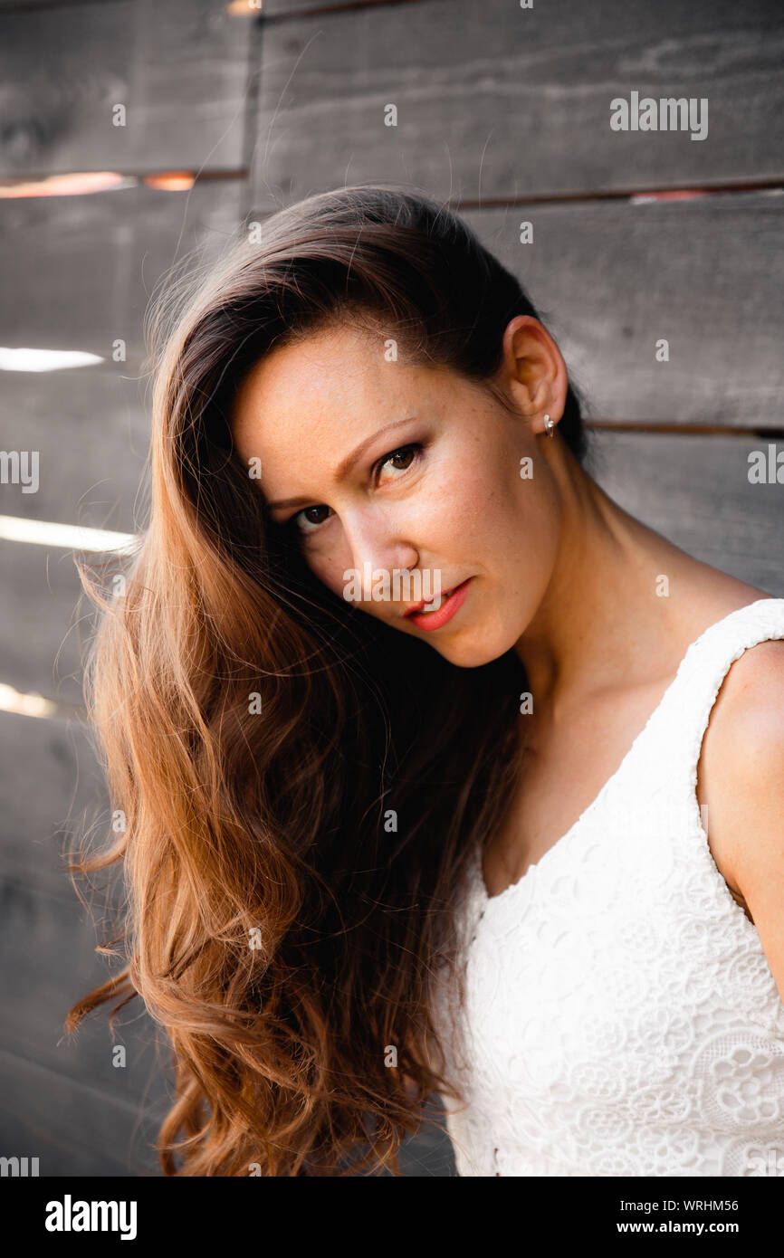 Beautiful woman in white portrait in an outdoor cafe garden with summer ...