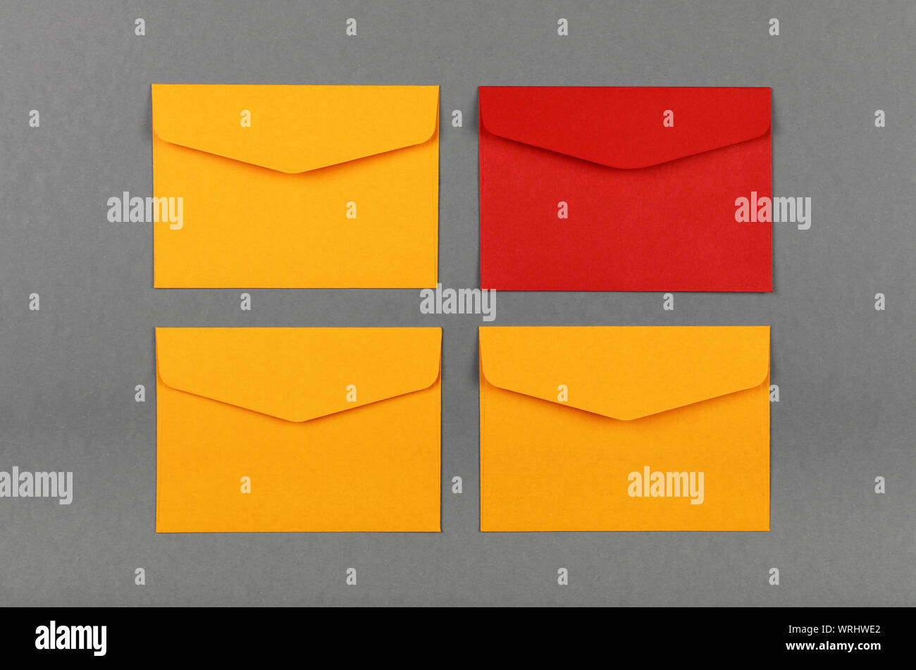 Four unopen yellow and red paper mail envelopes over grey background ...