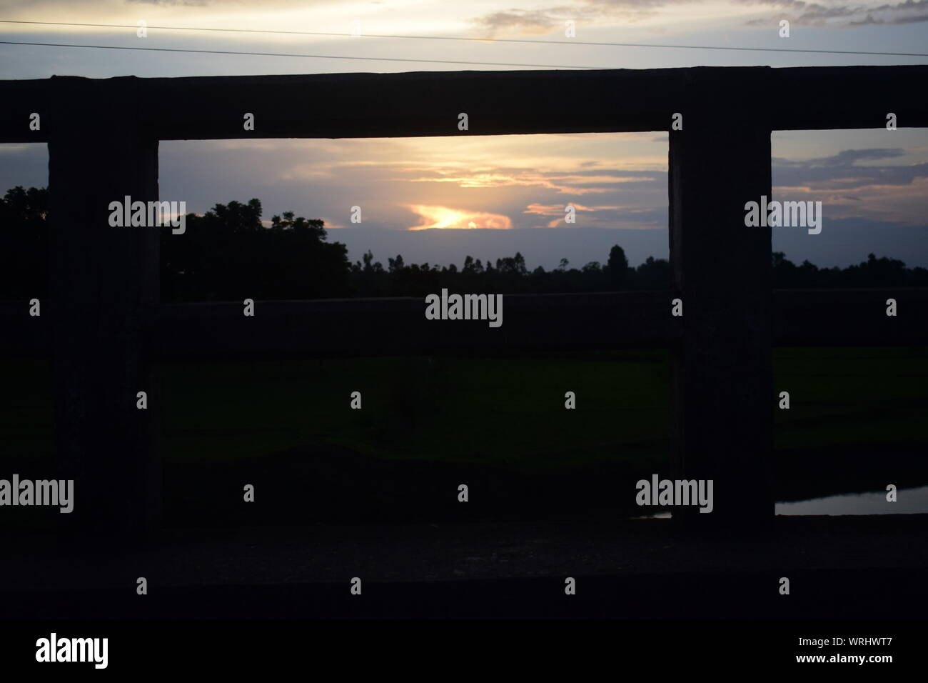 sunset through the railing of a bridge Stock Photo - Alamy