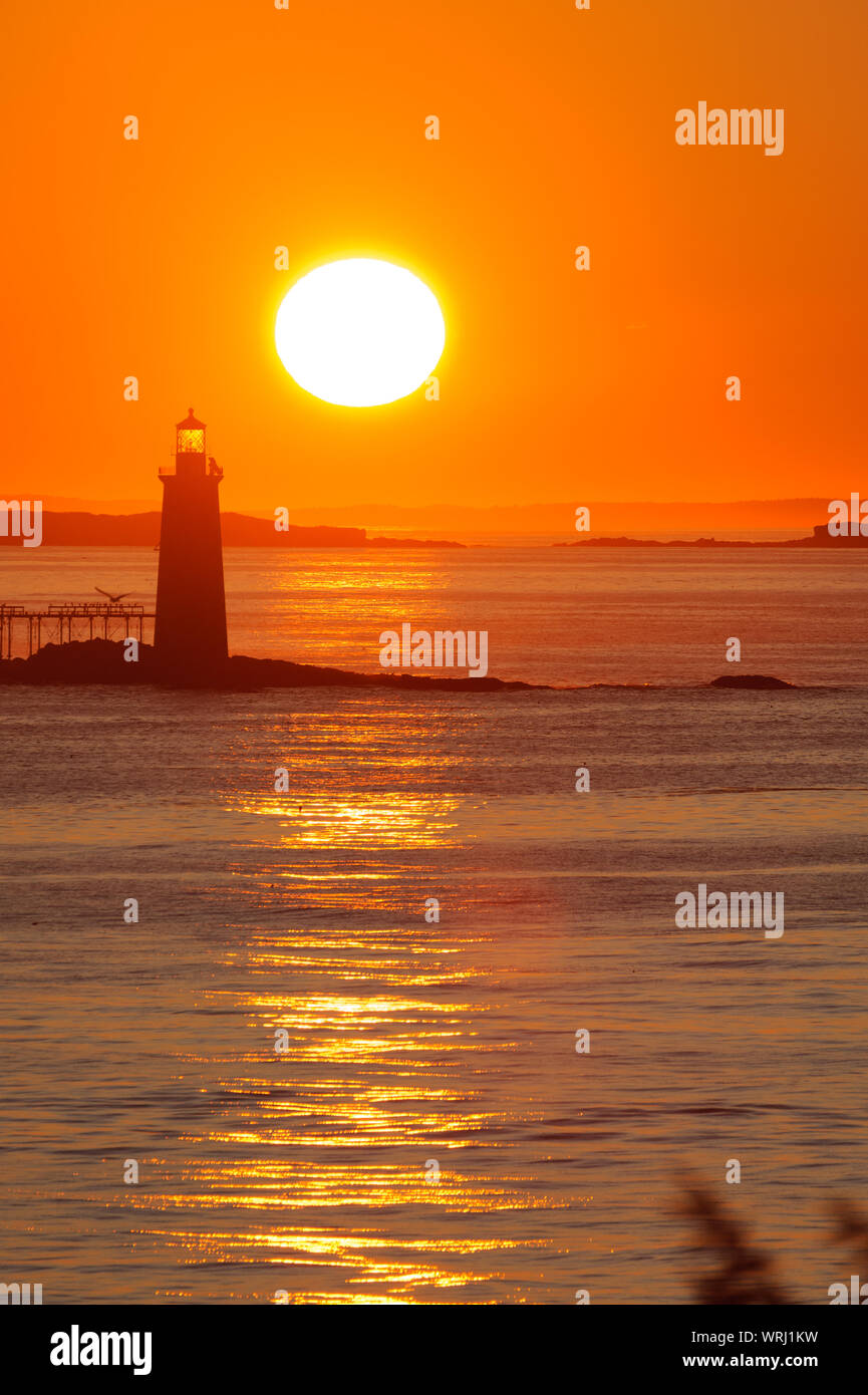Ram Island Ledge Lighthouse with a sunrise reflecting off the ocean ...