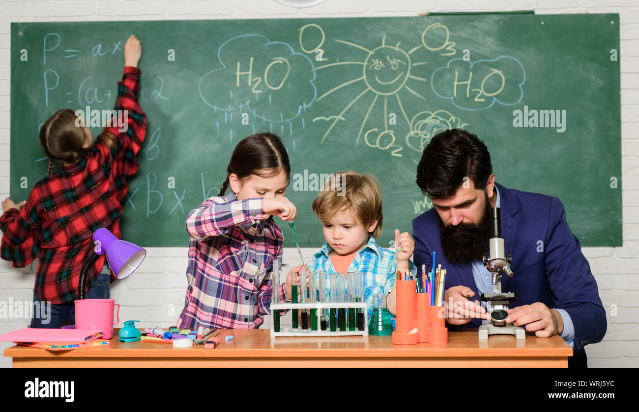 Explaining chemistry to kids. Fascinating chemistry lesson. Man bearded ...