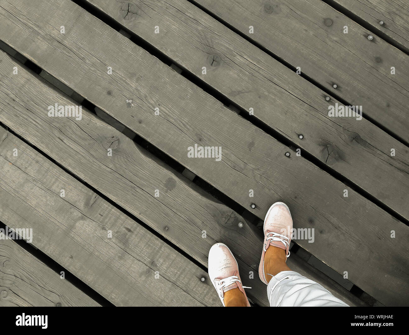 Personal perspective of woman legs standing on wooden floor, space for ...