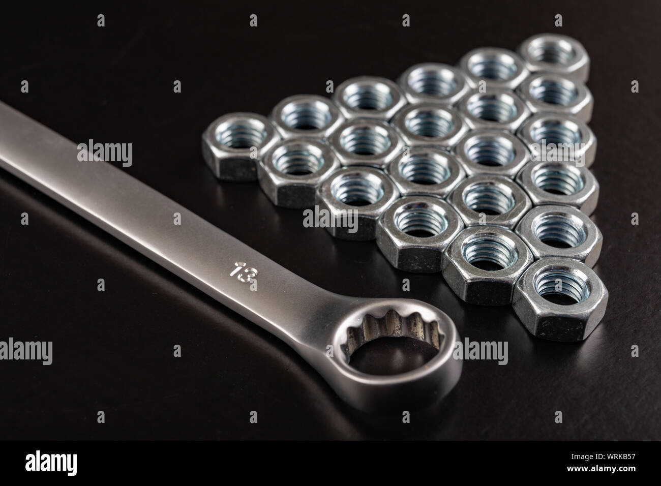 Nickel-plated nuts and wrenches on a workshop table. Tools in a ...