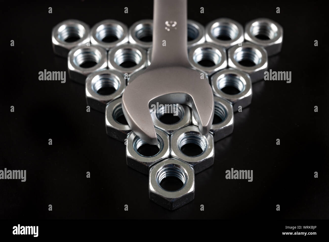 Nickel-plated nuts and wrenches on a workshop table. Tools in a ...