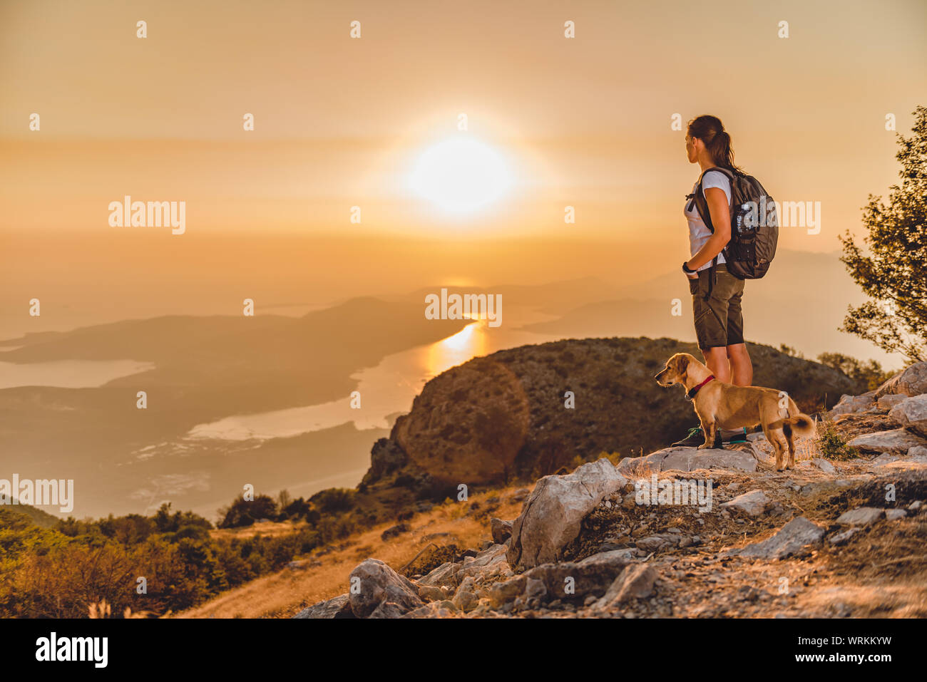 Back woman backpack looking sunset hi-res stock photography and images ...