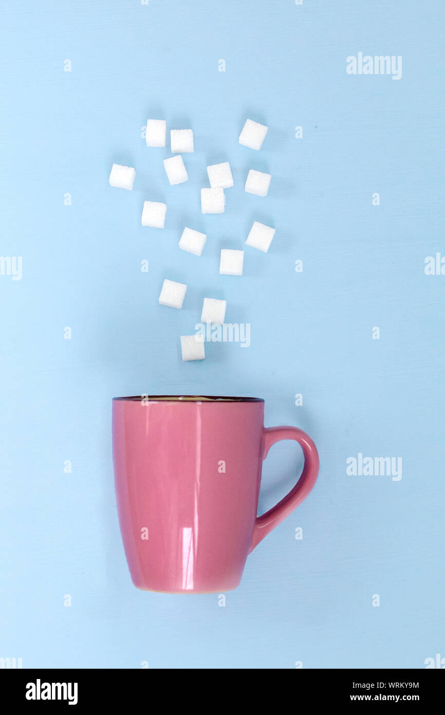 Sugar cubes levitation falling to the pink cup Stock Photo - Alamy