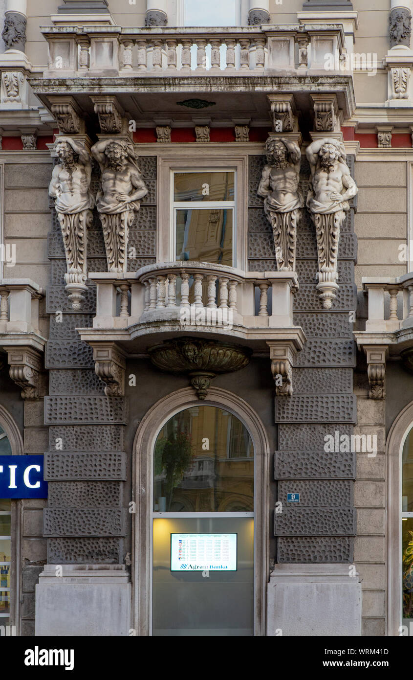 An ornate stone balcony with stone statues on either side of the door ...