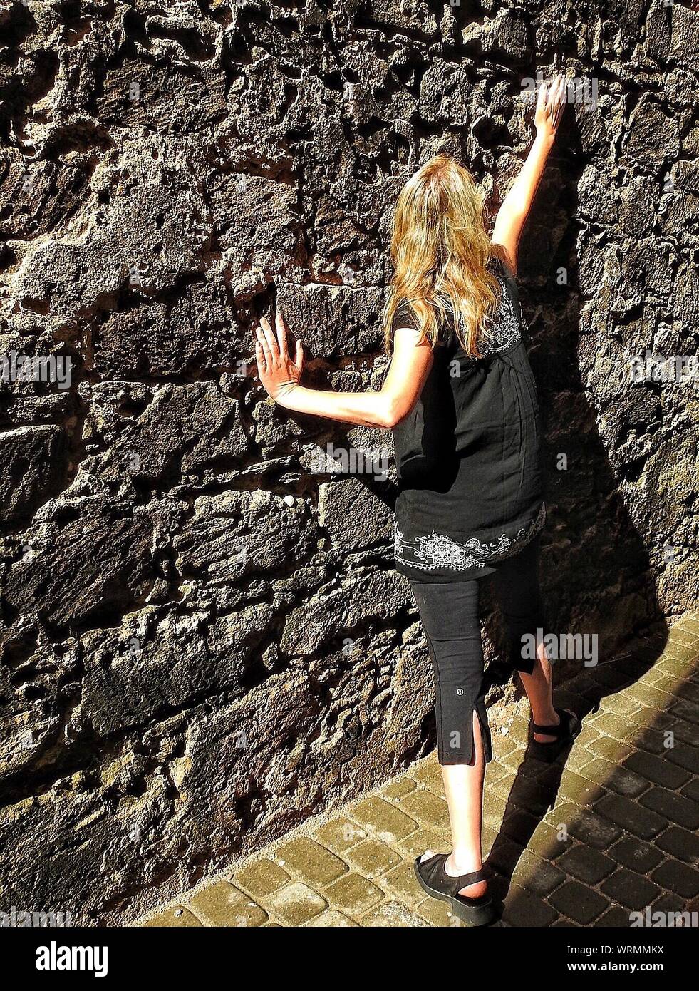 View Of Woman Hugging Wall Stock Photo - Alamy
