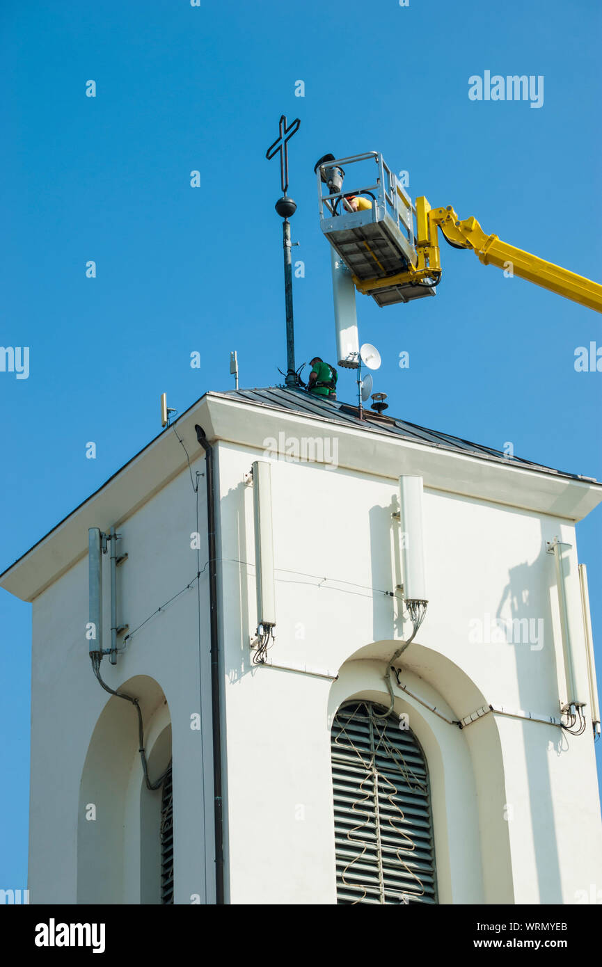 Cellphone base station antenna installation work on a church in central ...