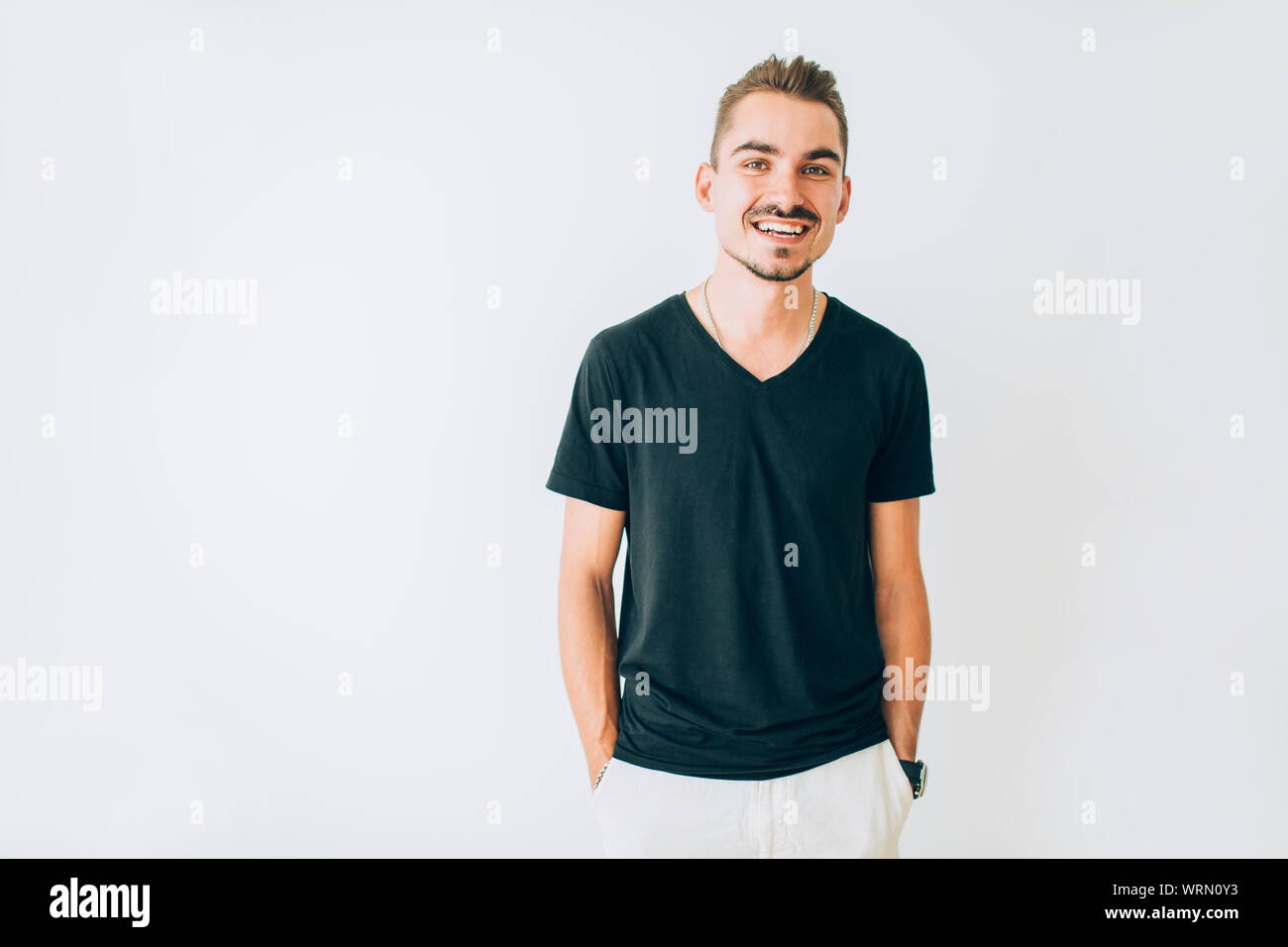 Happy young guy in black t-shirt posing on white isolated background ...