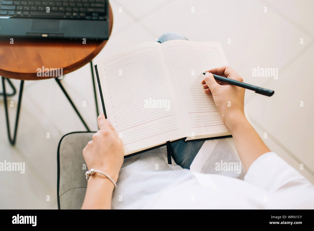 Female hands writing in a notepad, overview. Businesswoman working in a ...