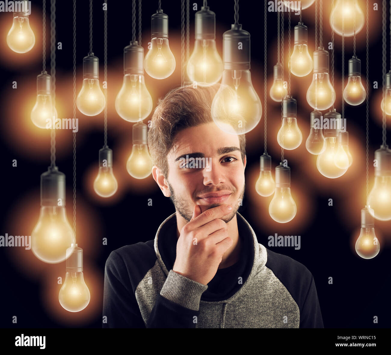 Young smart boy illuminated by light bulbs. Concept of creativity idea ...