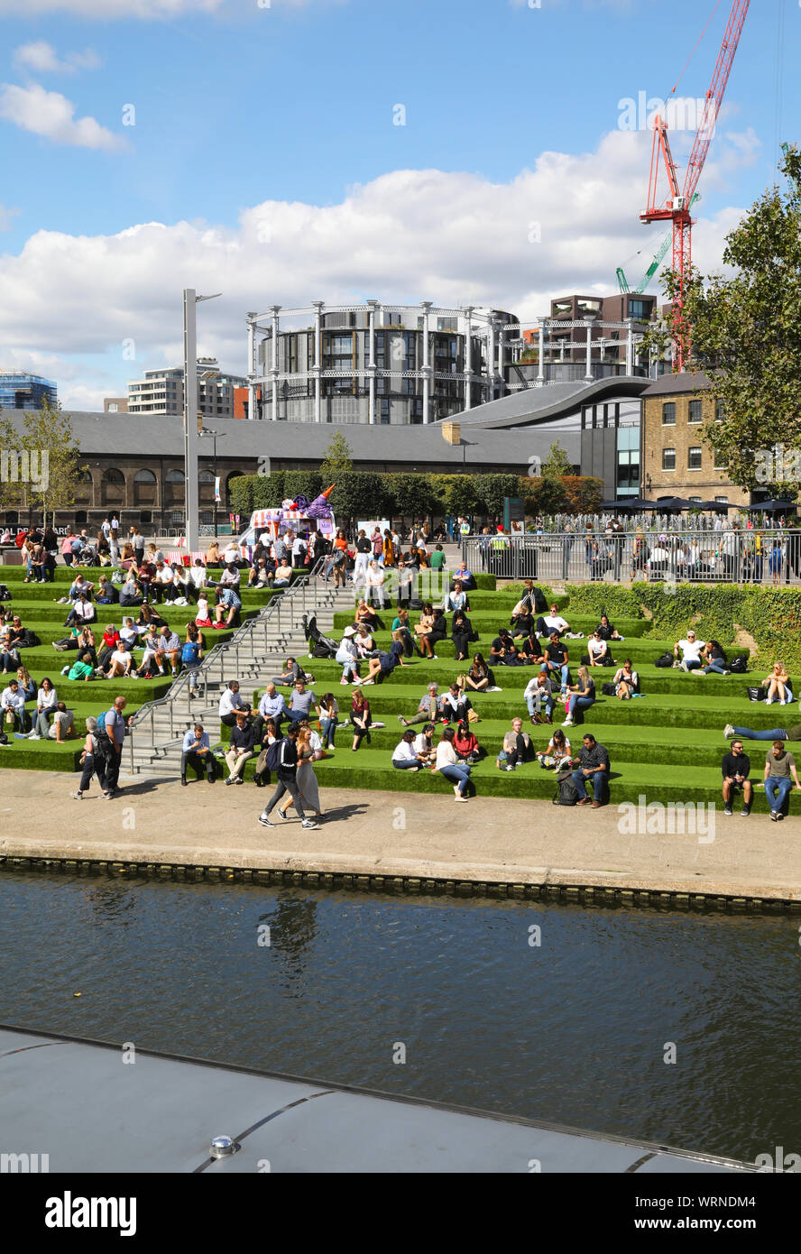 The grass steps leading down from Granary Square to Regents Canal at ...