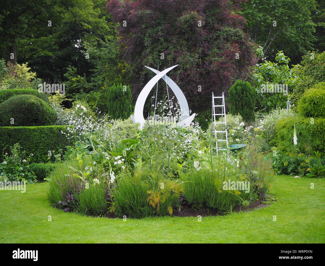 Chenies Manor topiary garden with garden maintenance in progress ...