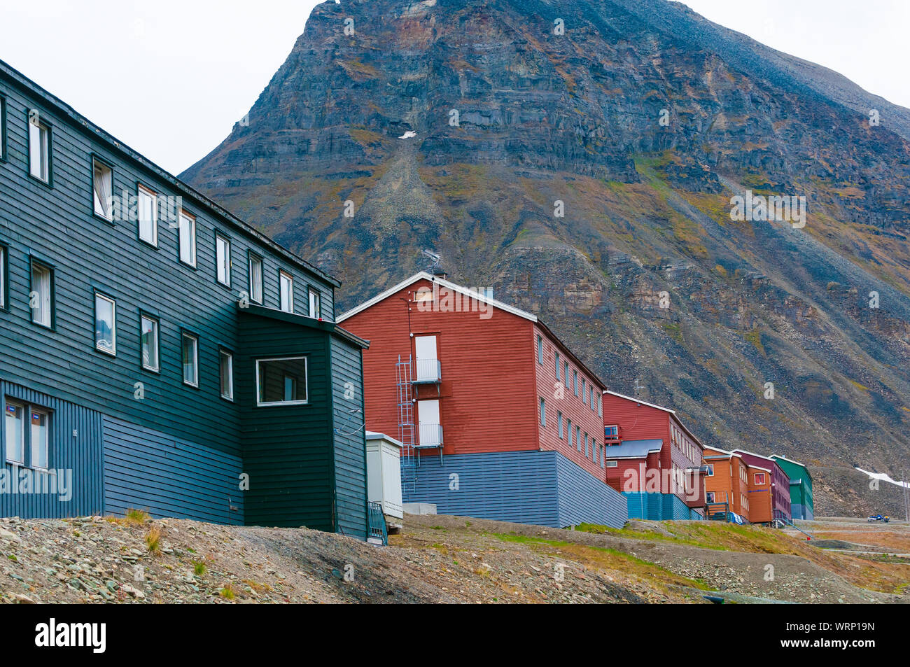Colorful buildings beneath a mountain in the town of Longyearbyen ...
