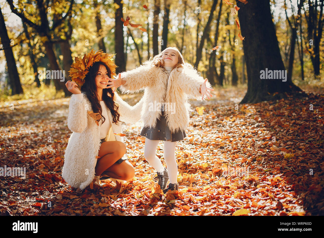 Beautiful mother with daughter. Family in a autumn park. Golden autumn ...