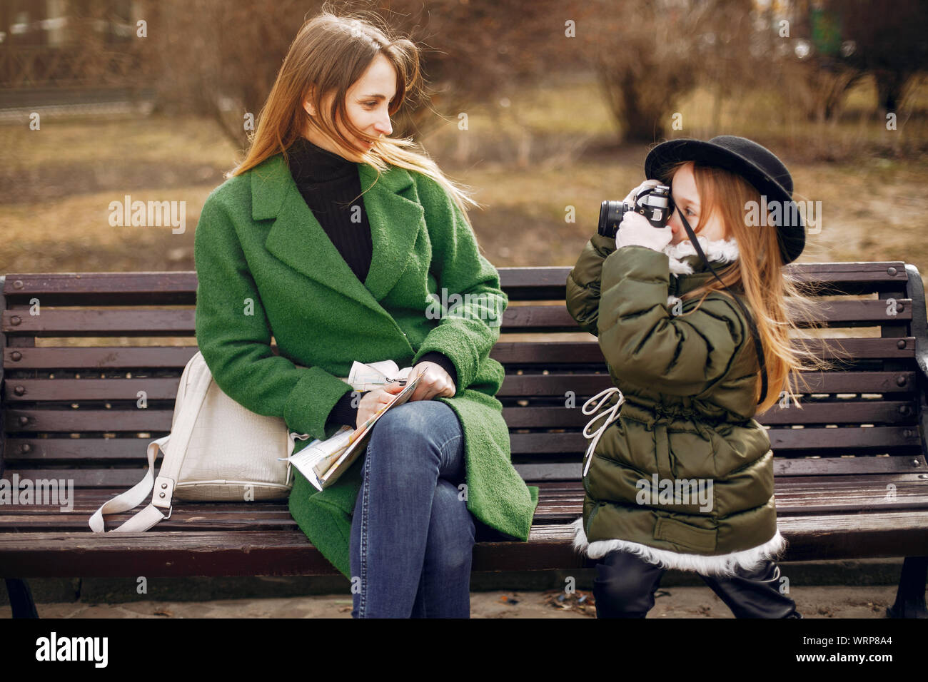 Fashionable mother with daughter. Family with a travel map Stock Photo ...