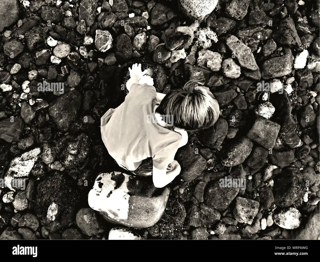 Boy sitting on rocks hi-res stock photography and images - Alamy