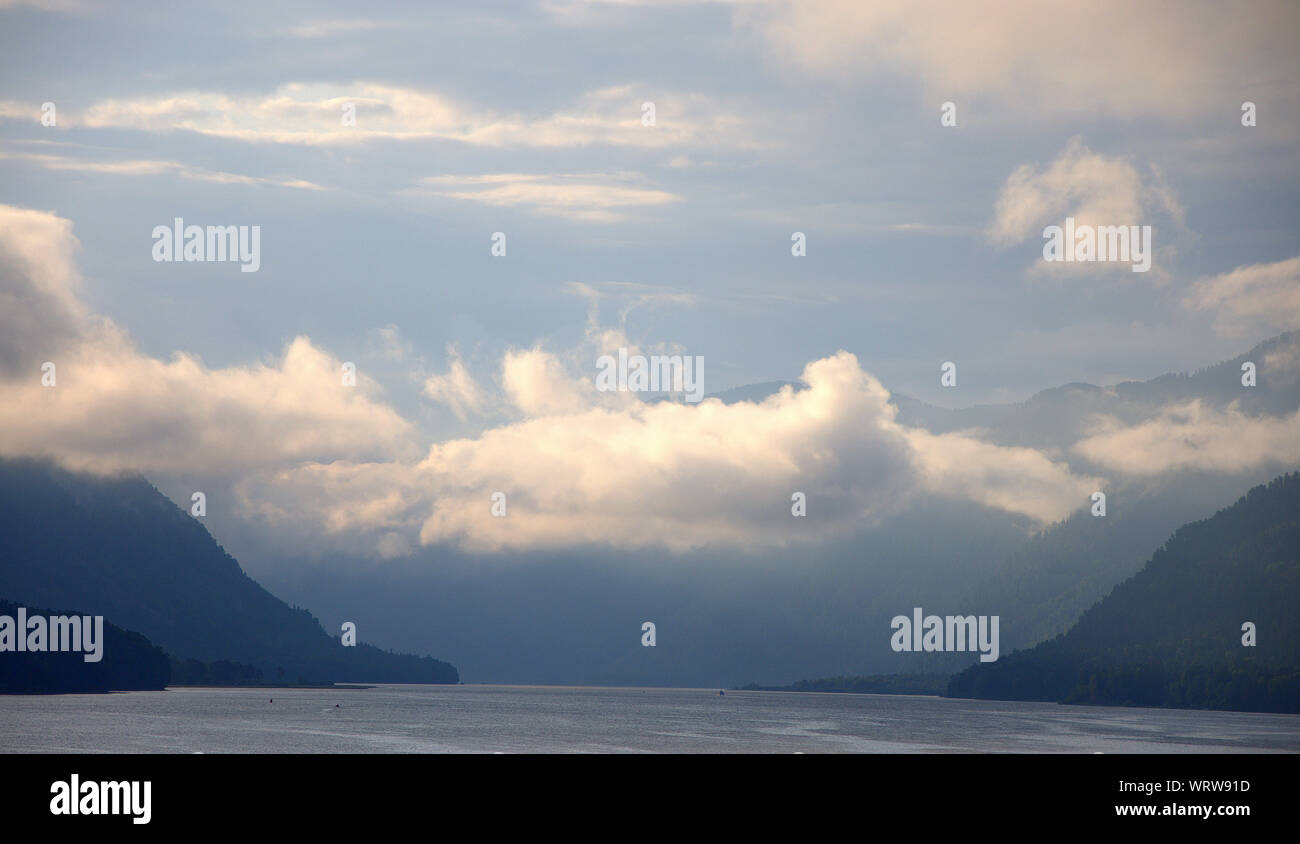 Low clouds before the rain descend from the mountains to the surface of ...