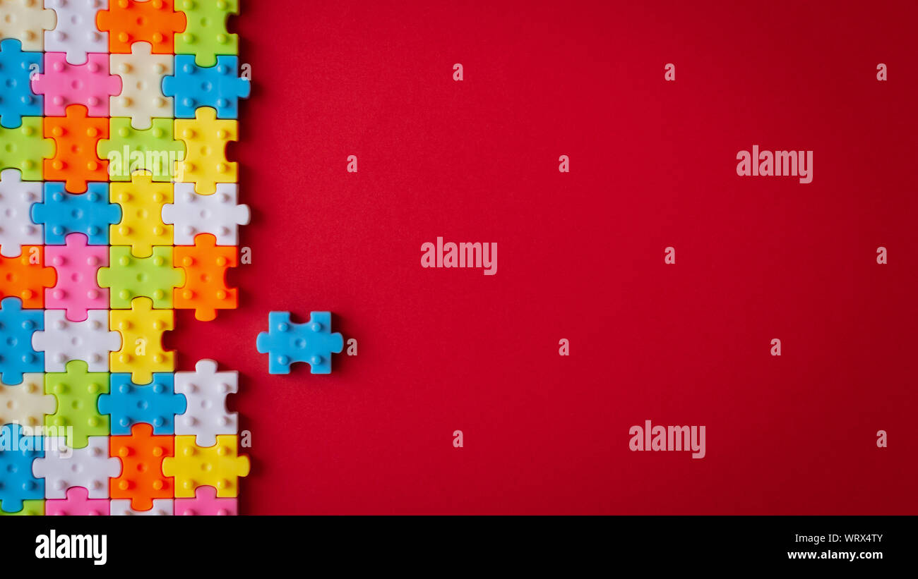 Colors plastic jigsaw puzzle on red paper background, Missing one ...