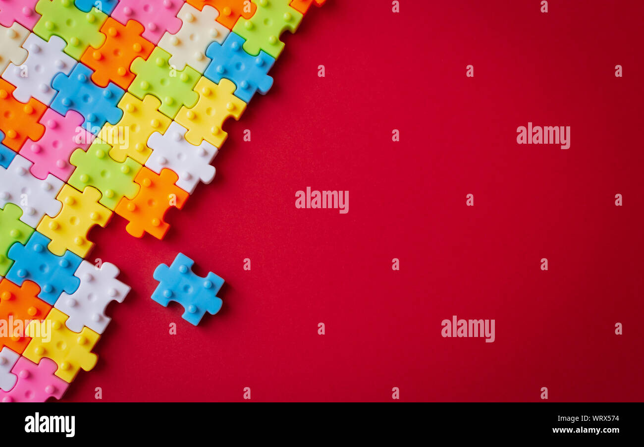 Colors plastic jigsaw puzzle on red paper background, Missing one ...