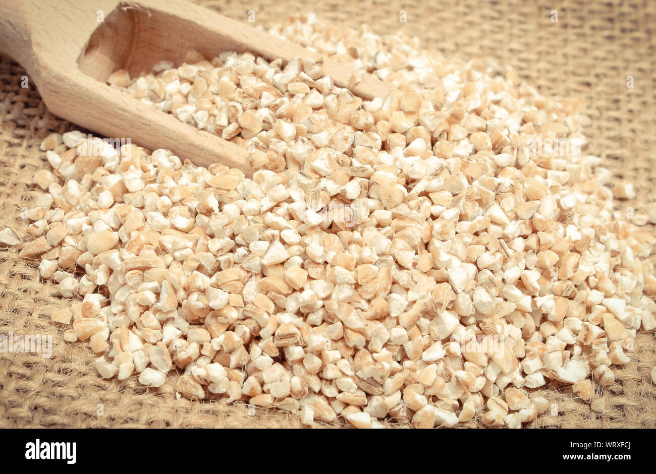 Barley groats with wooden scoop. Food containing natural minerals and ...