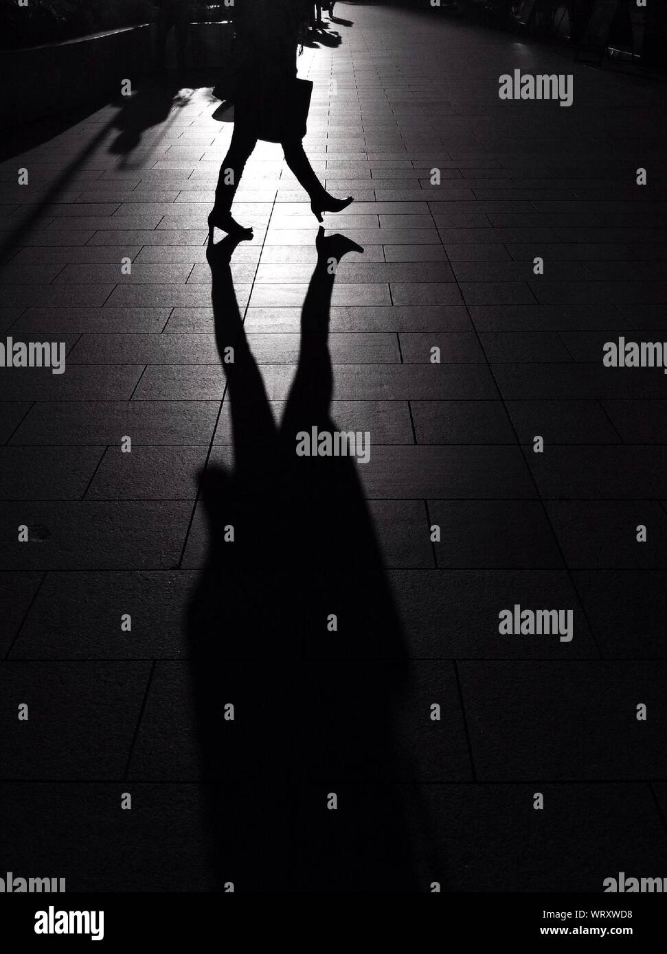 Shadow Of Woman Walking On Street At Night Stock Photo - Alamy